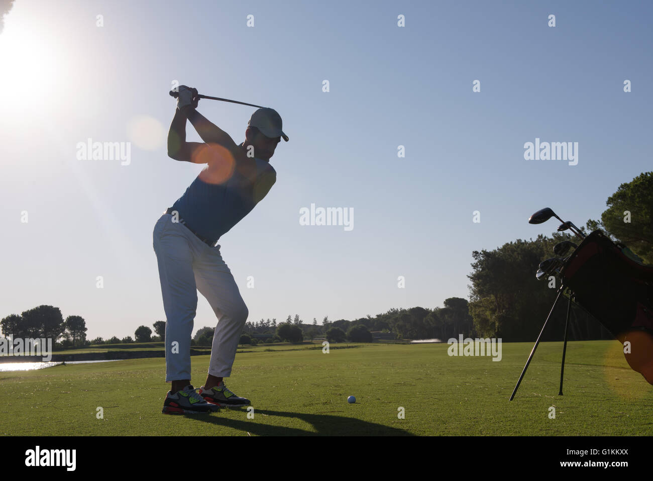 golf player hitting shot with club on course at beautiful morning with ...