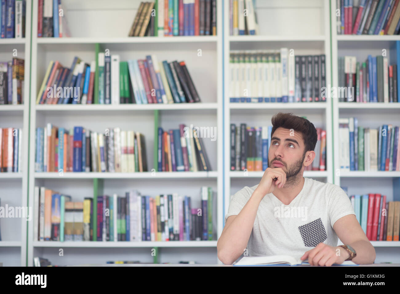Student reading book in school library. Study lessons for exam. Hard ...