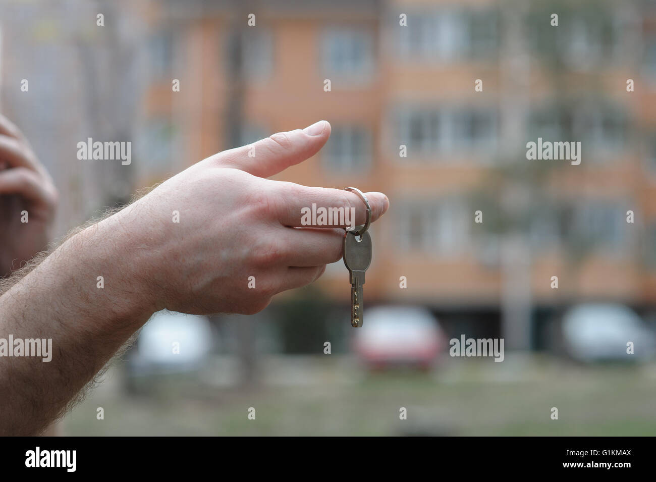 Man hand holding house key concept realtor work Stock Photo - Alamy