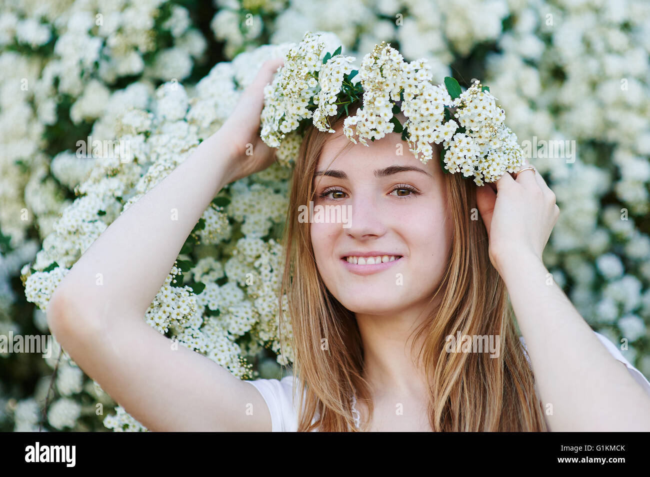 beautiful woman walking in the park near the white flowering trees ...