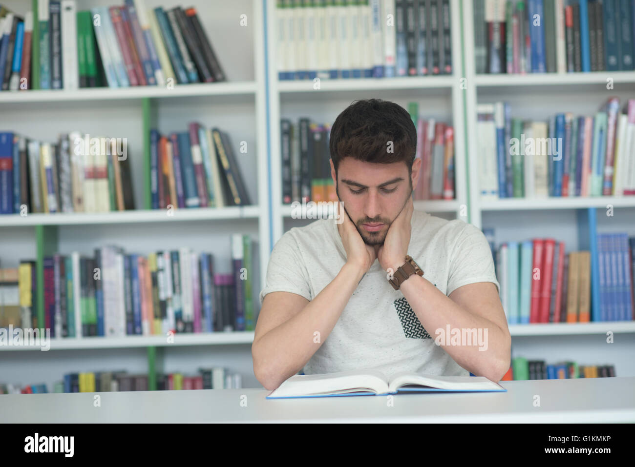 Student reading book in school library. Study lessons for exam. Hard ...