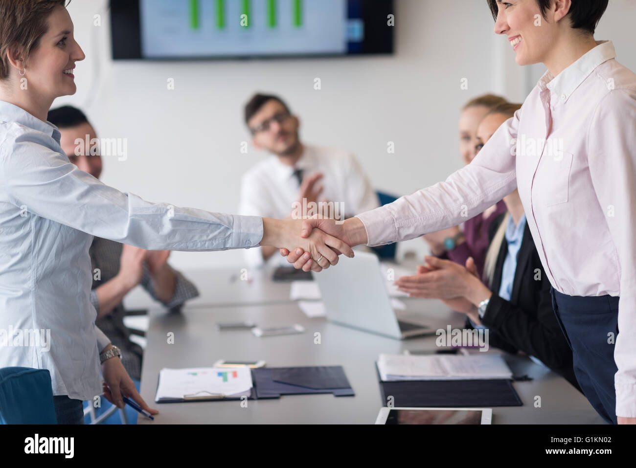 businesswomans handshake on team meeting with group of people blured in ...