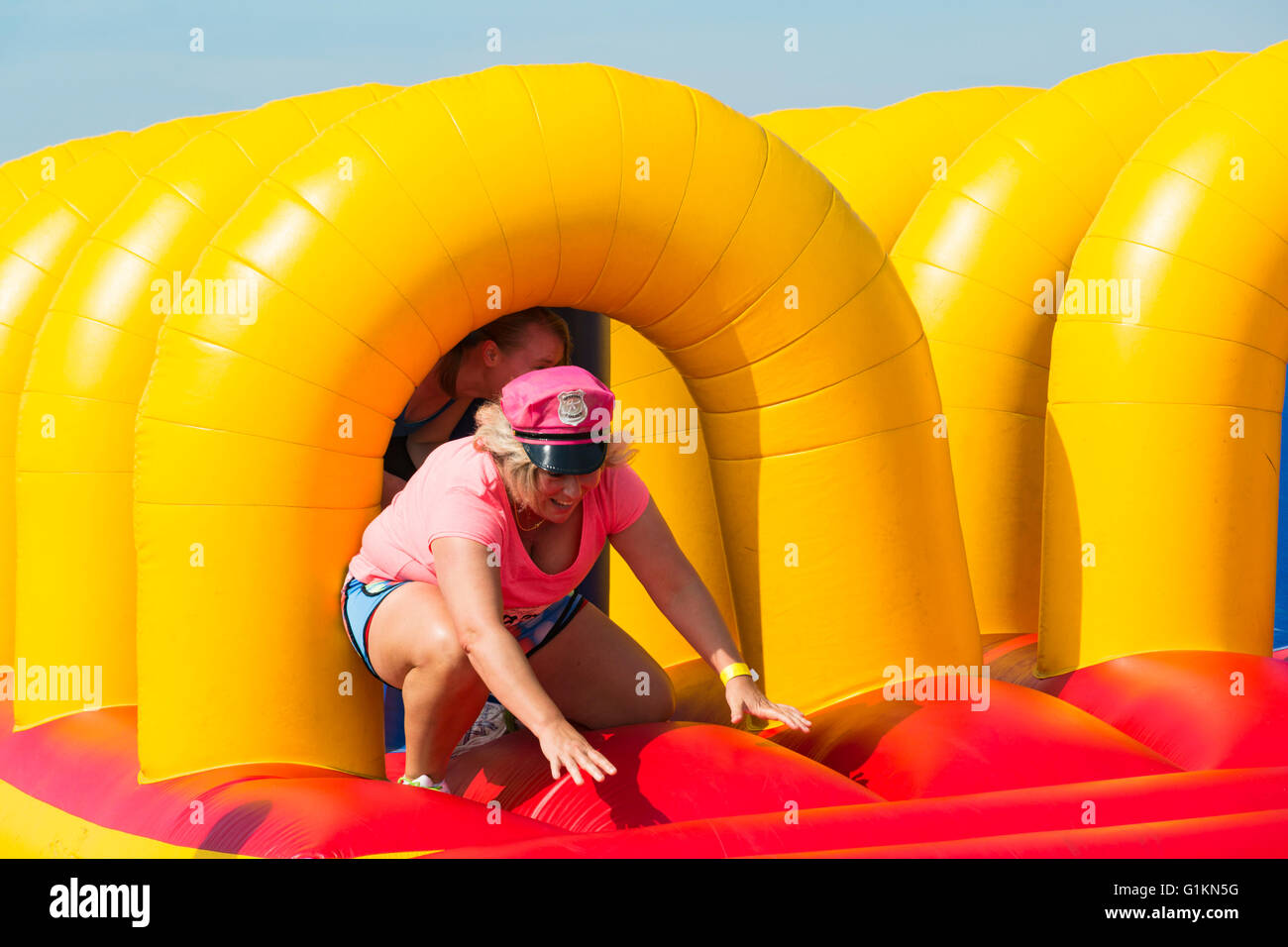 Woman crawling through inflatable obstacle course at Poole, Dorset UK ...