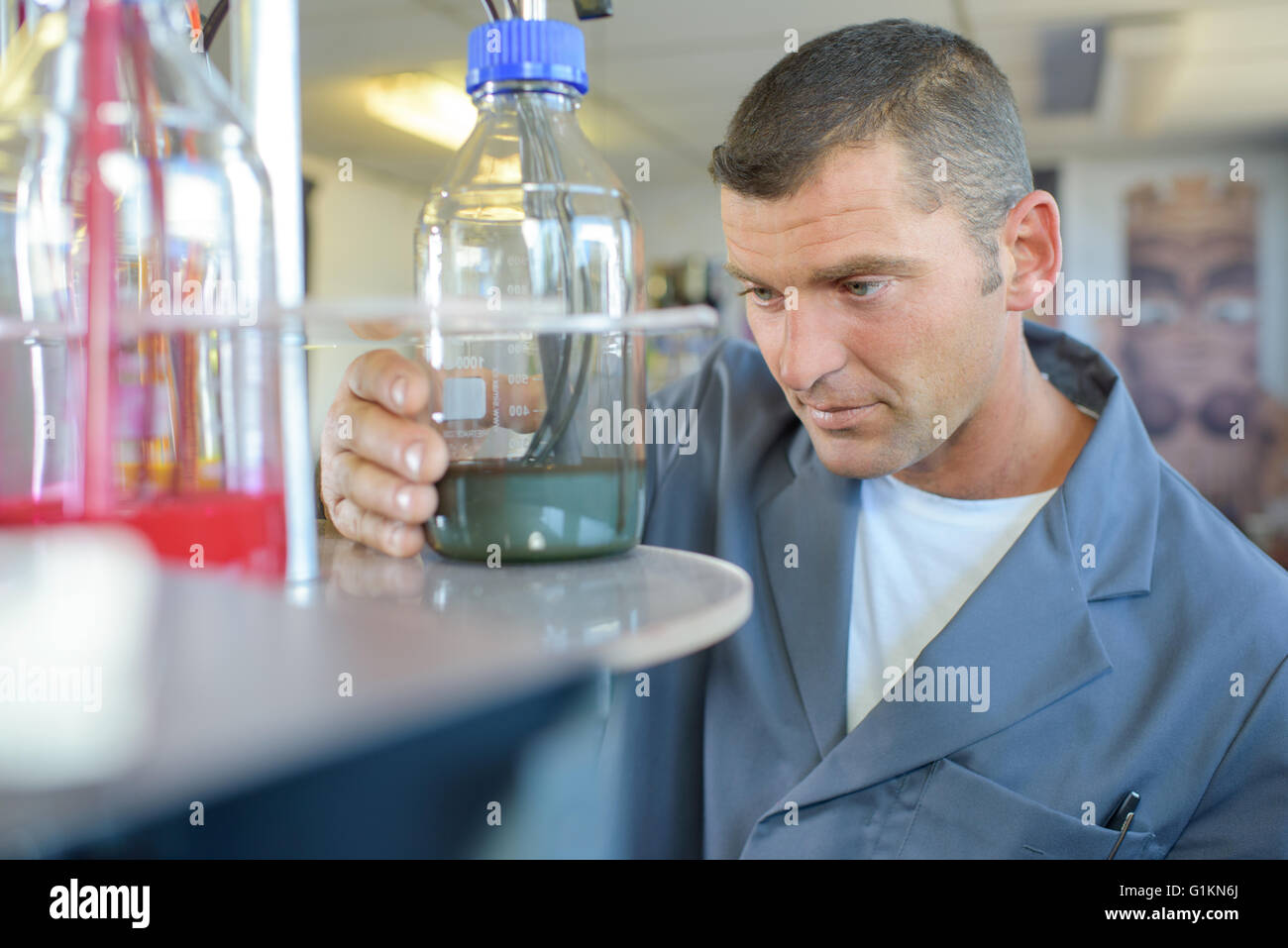 Man looking at glass jar Stock Photo - Alamy