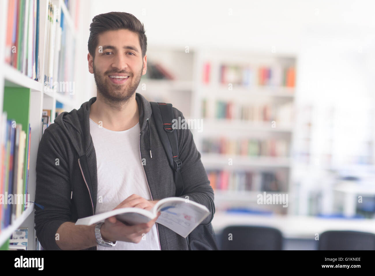 Portrait of happy student while reading book in school library. Study ...