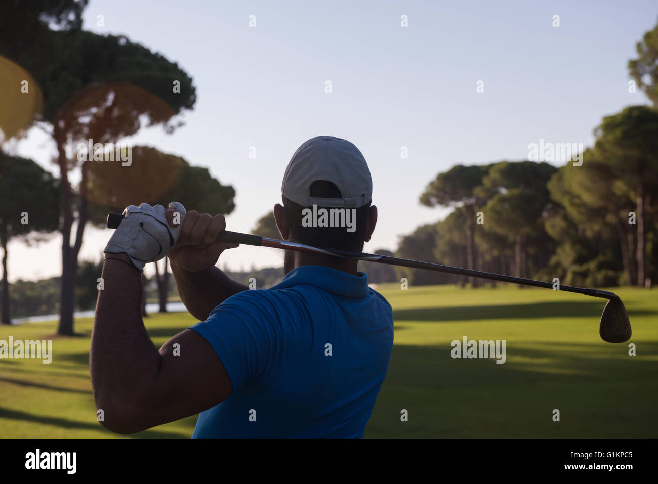 golf player hitting shot with club on course at beautiful morning with ...