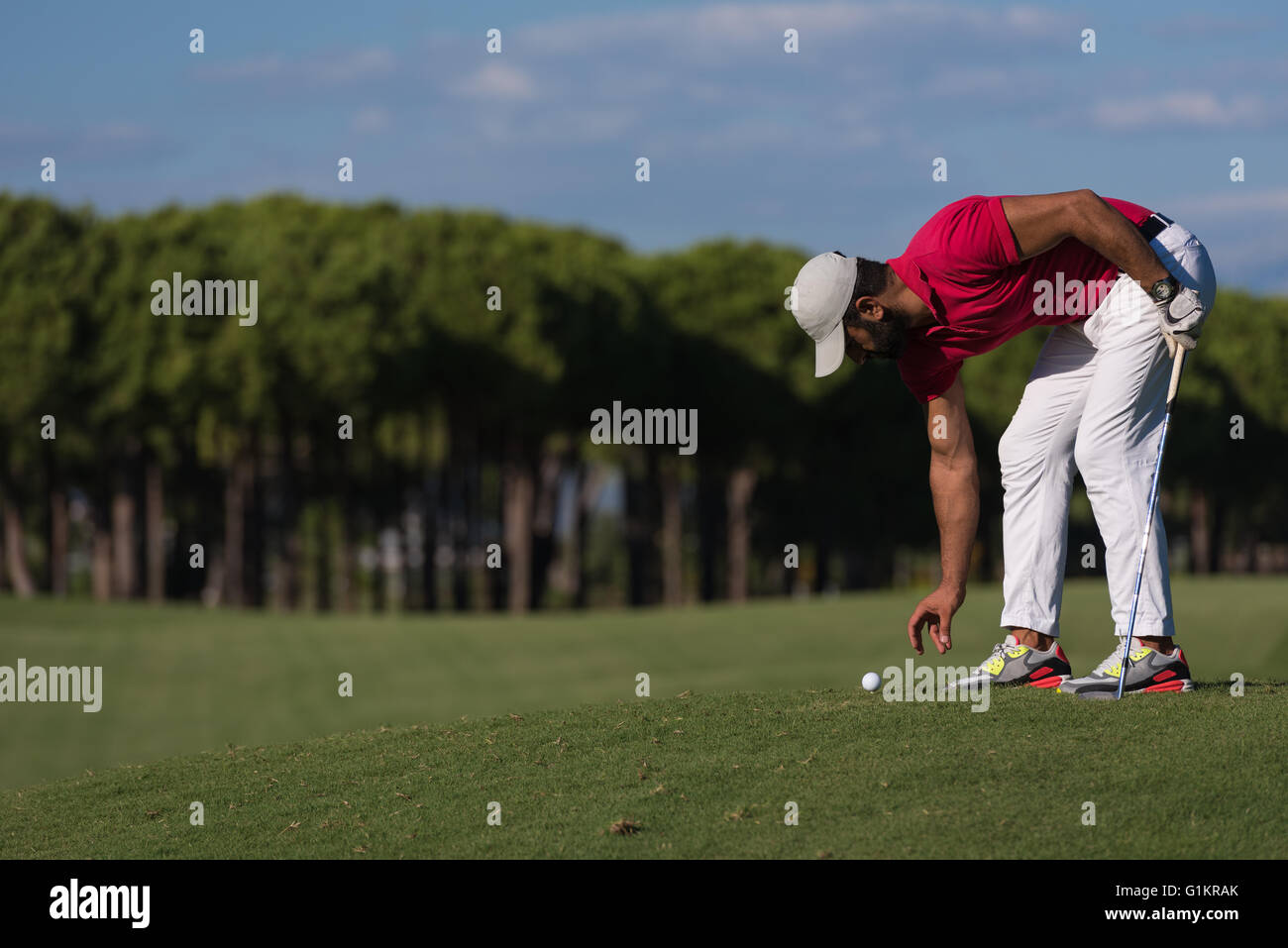 golf player hitting shot with driver on course at beautiful sunny day ...