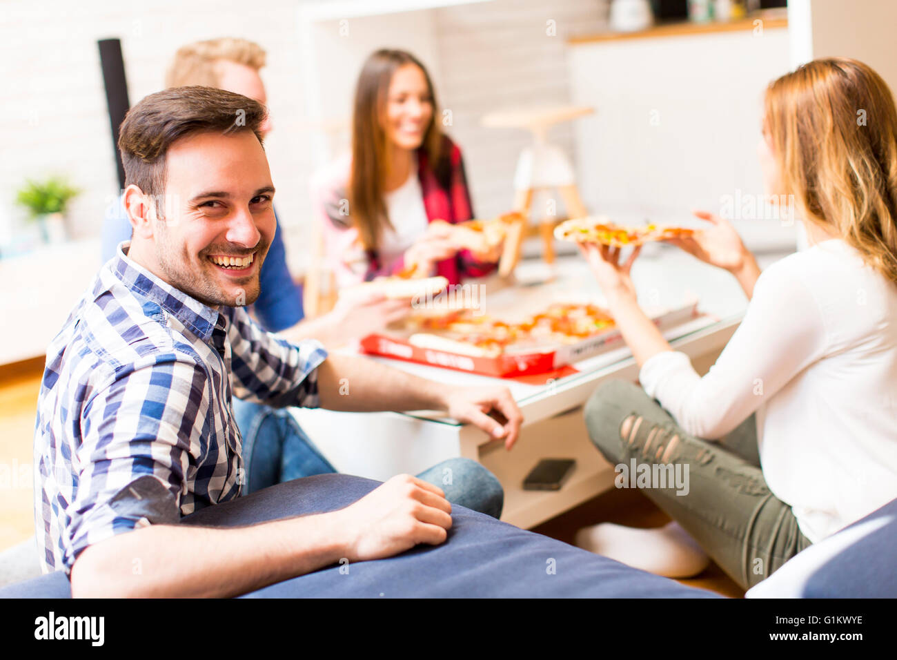 Group of friends eating pizza together at home Stock Photo - Alamy