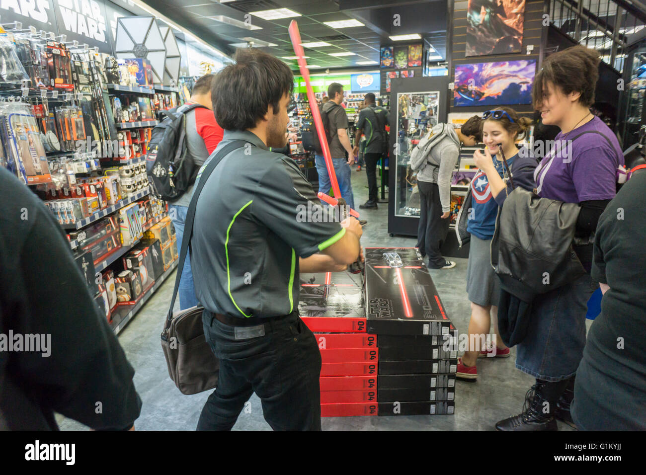 A sales associate demonstrates the proper use of a Star Wars LightSaber ...
