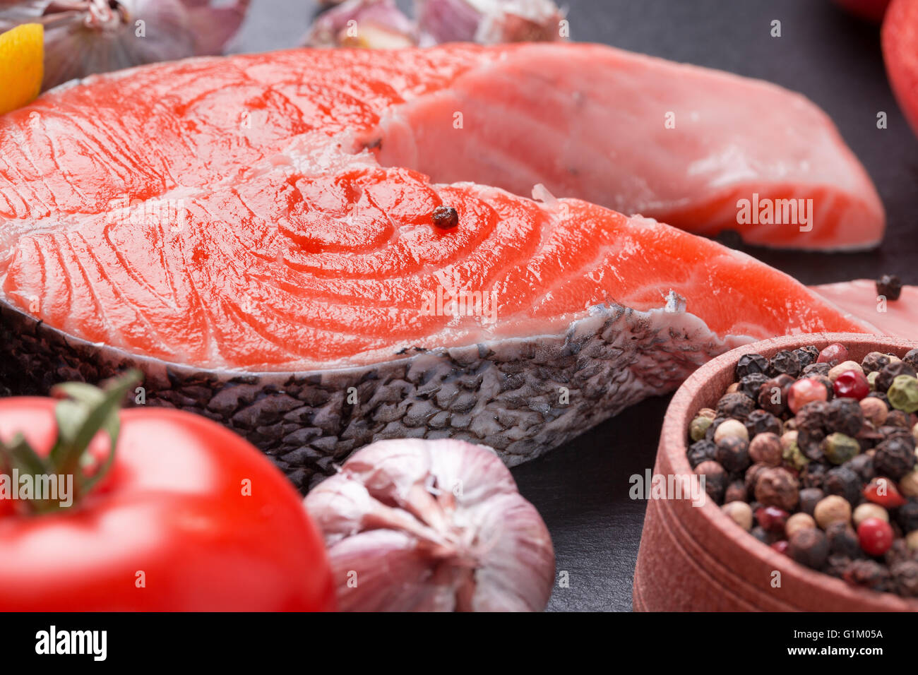red fish steak with spices and vegetables on a slate table Stock Photo ...
