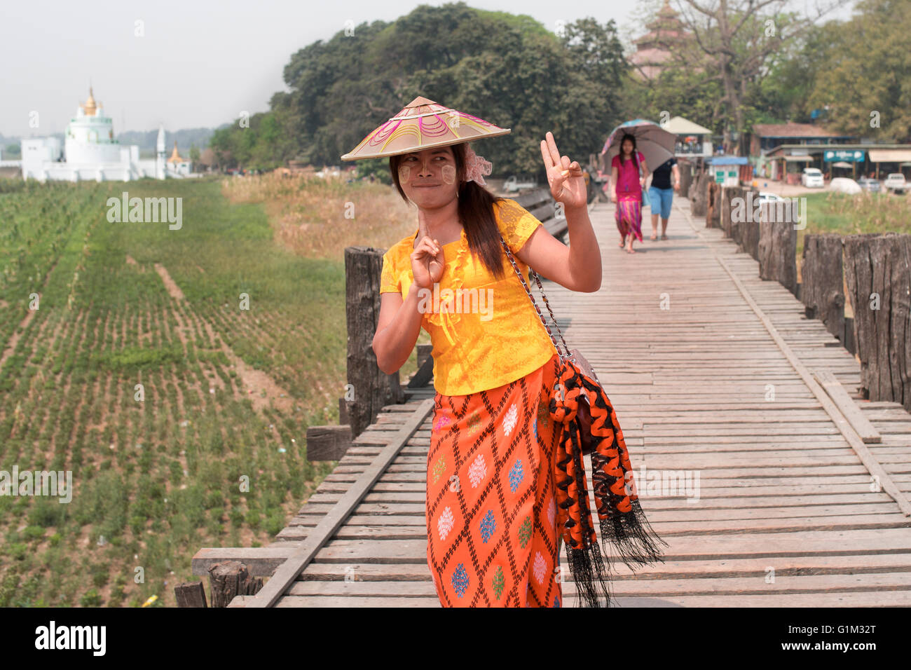 Myanmar woman with thanaka facial cream in the traditional longyi or ...