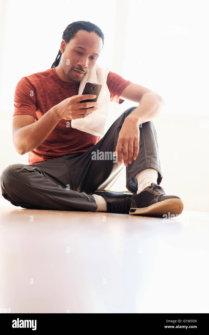 Black man using cell phone on floor Stock Photo - Alamy