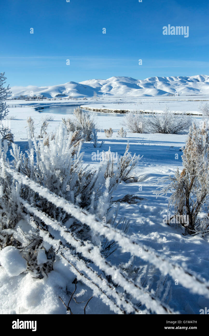 Frosty fence and river in snowy rural landscape Stock Photo - Alamy