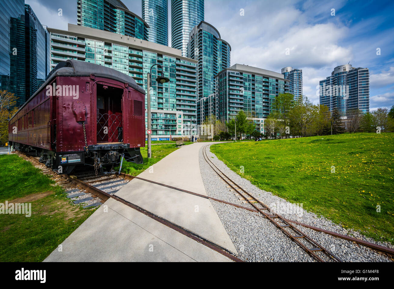 Railroad car at Roundhouse Park and modern buildings in downtown ...