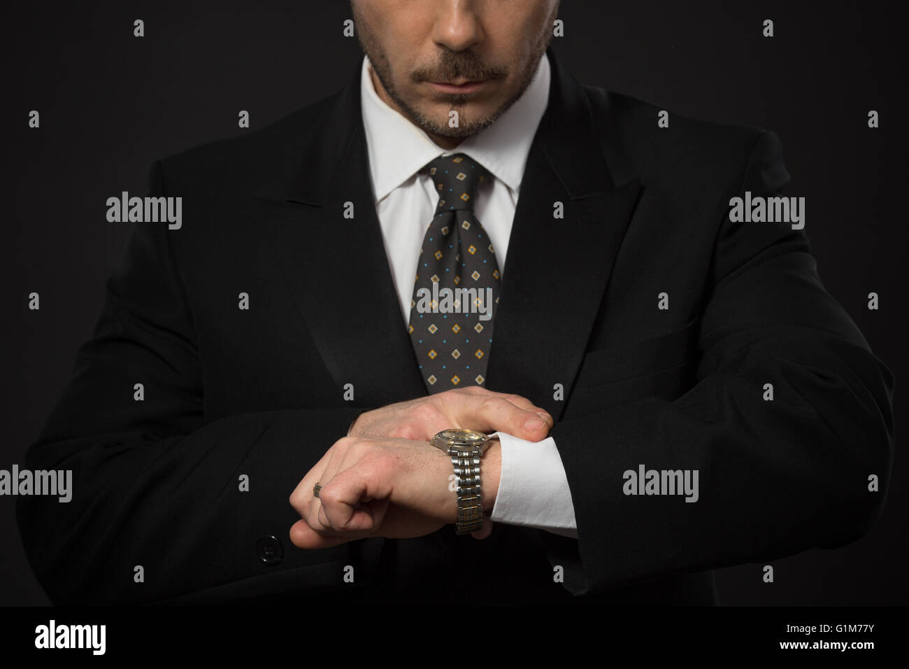 Businessman checking time Stock Photo - Alamy