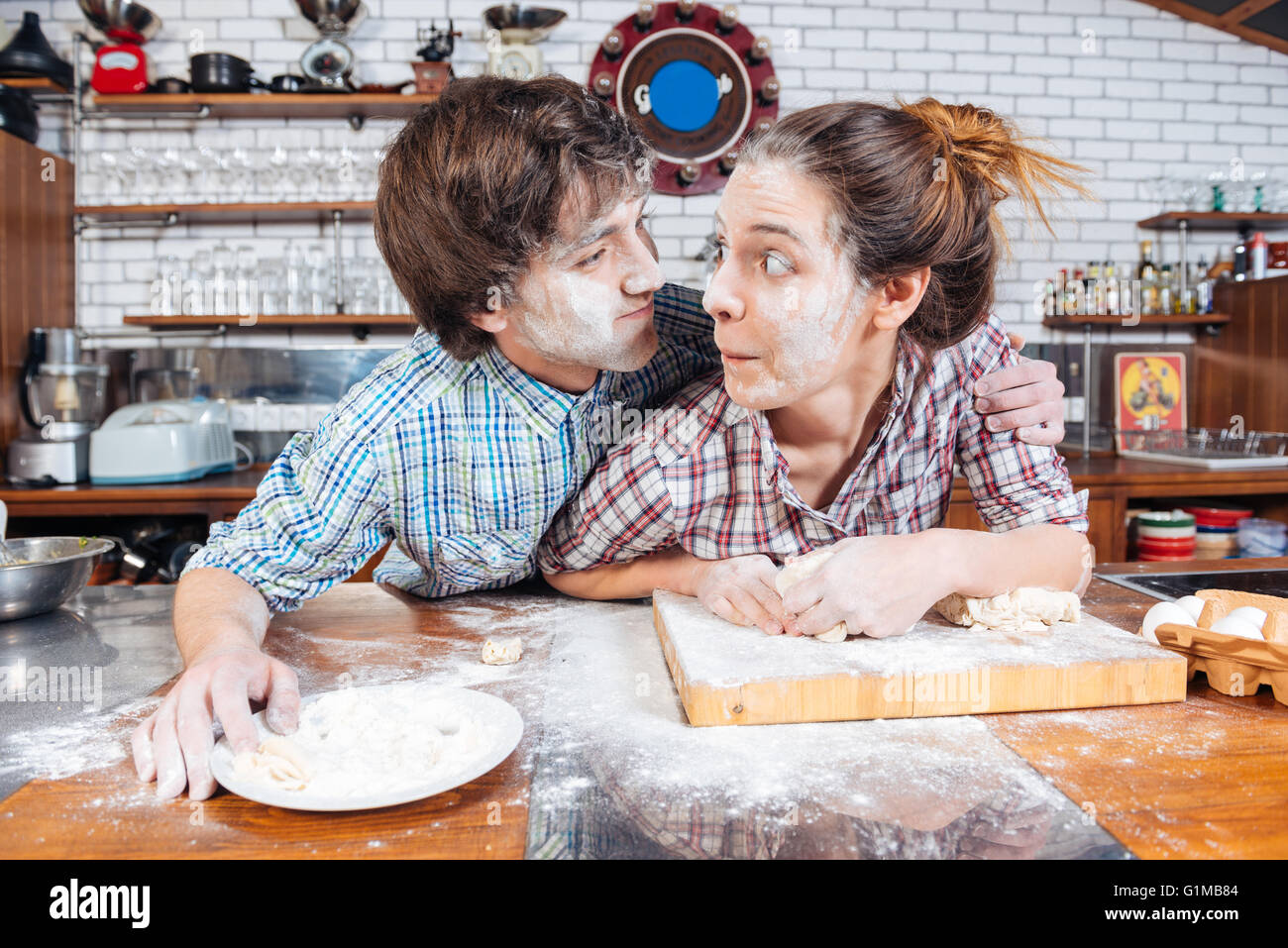 Amusing young couple with flour on faces making funny faces on the ...