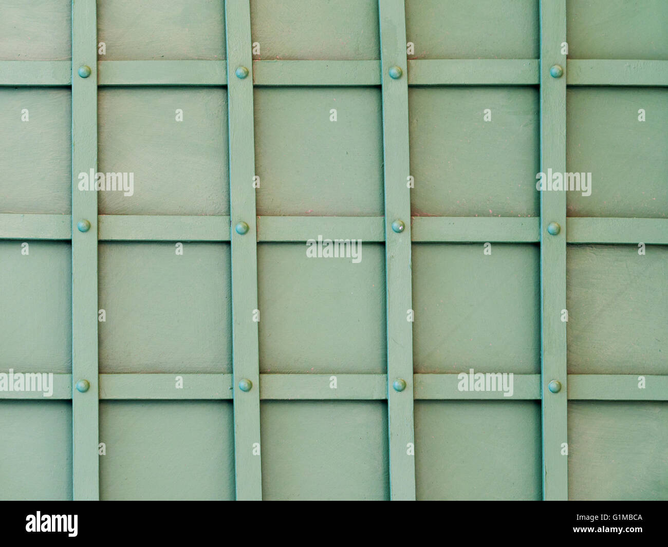 Geometric pattern of squares grid detail of a green iron gate door ...