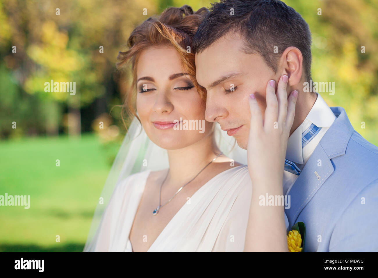 The groom gently embraces the bride Stock Photo - Alamy