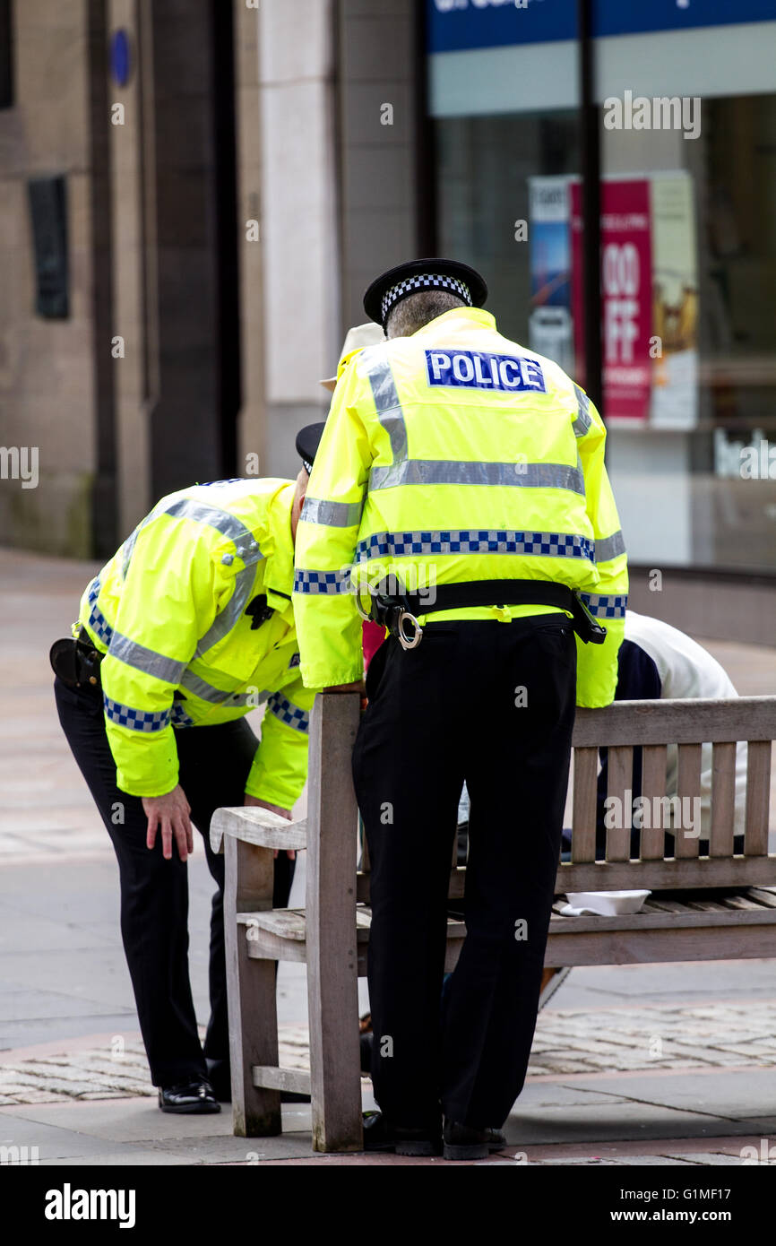 Police Scotland policemen assisting a person who was passed out on a ...
