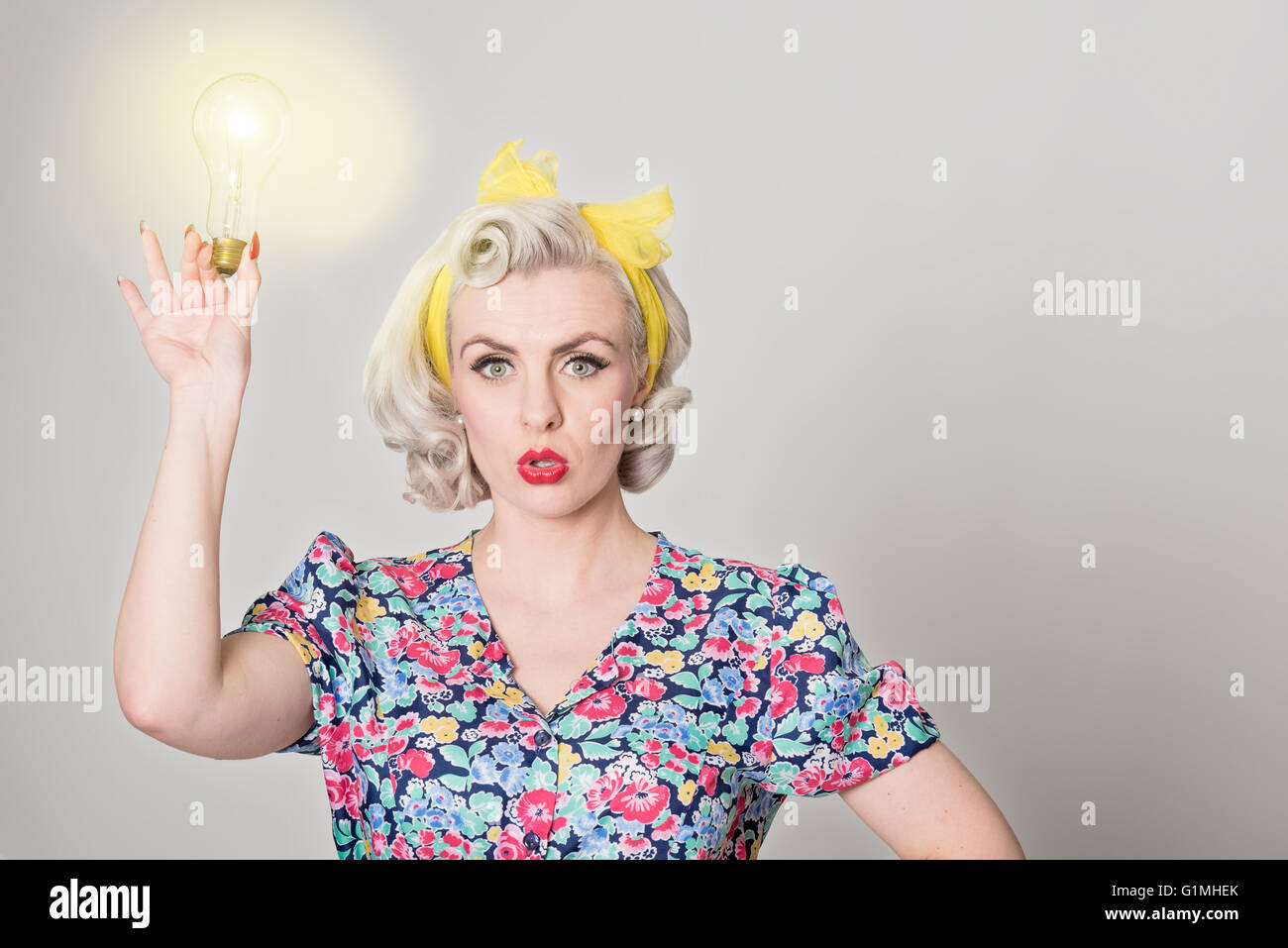 Cute blonde girl holding glowing light bulb - humorous concept Stock ...