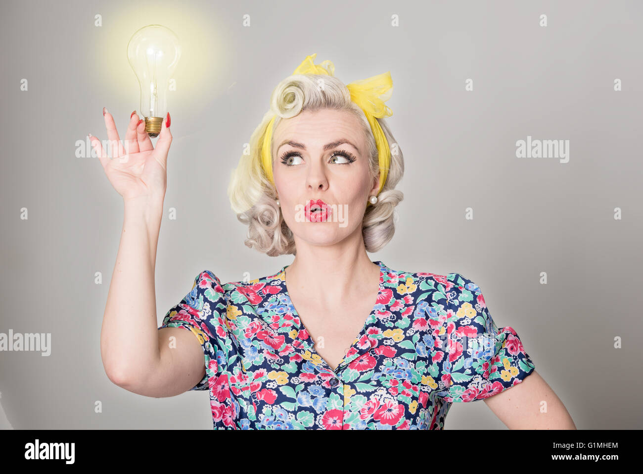 Cute blonde girl holding glowing light bulb - humorous concept Stock ...