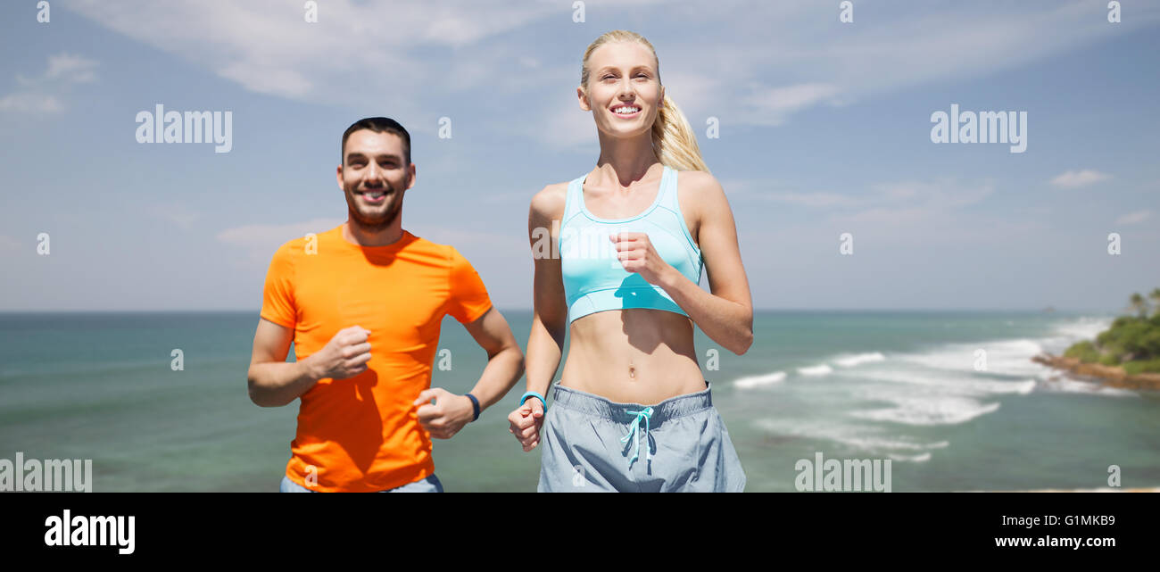 happy couple running over sea or beach background Stock Photo - Alamy