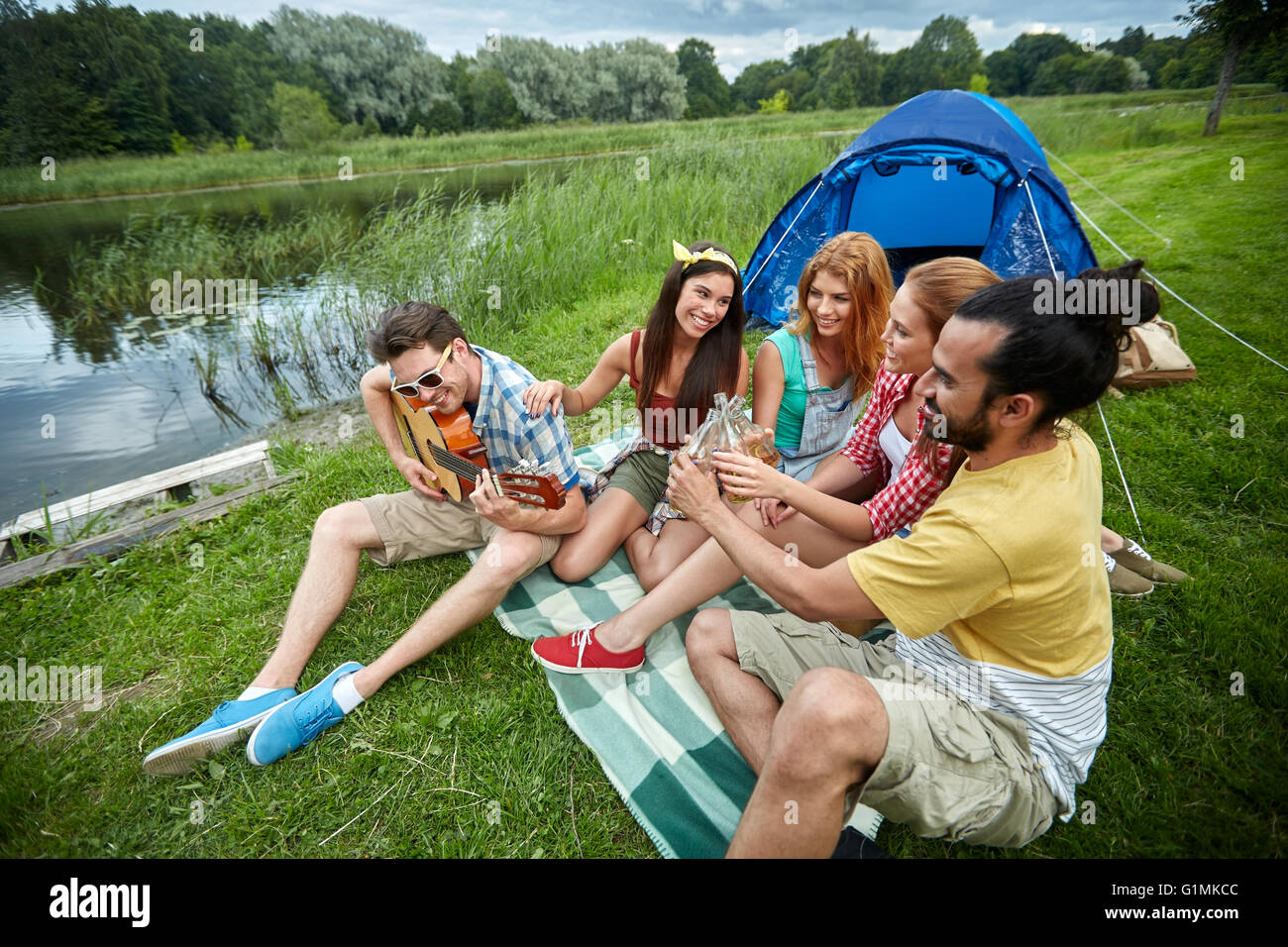 happy friends with drinks and guitar at camping Stock Photo - Alamy