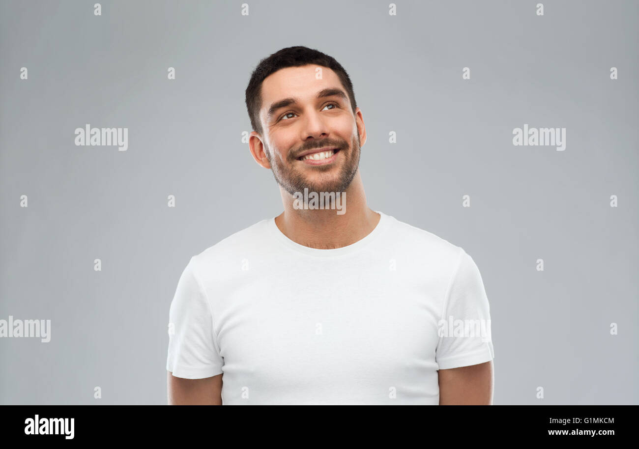 smiling man looking up over gray background Stock Photo - Alamy