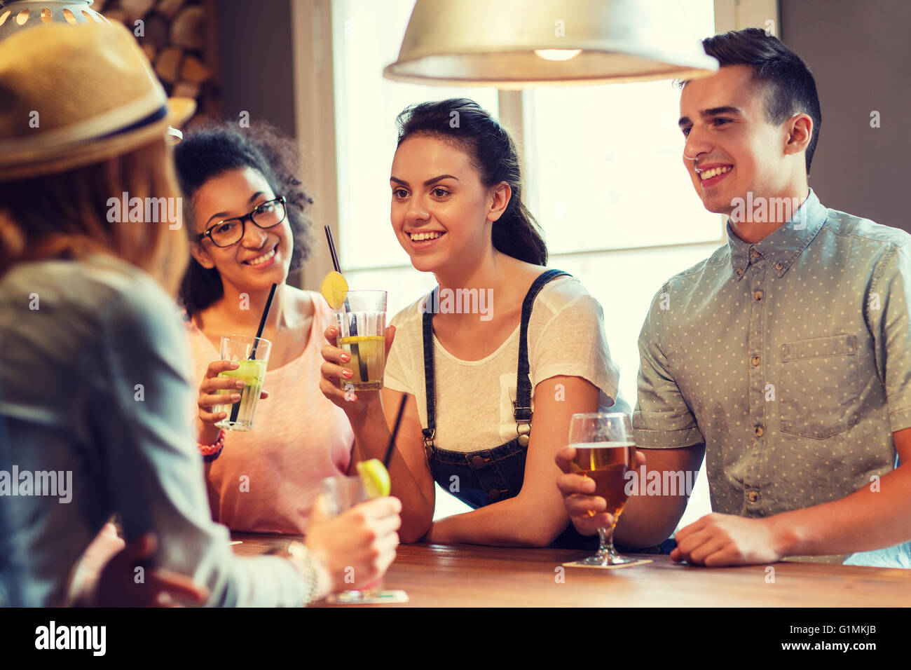 happy friends drinking beer and cocktails at bar Stock Photo - Alamy