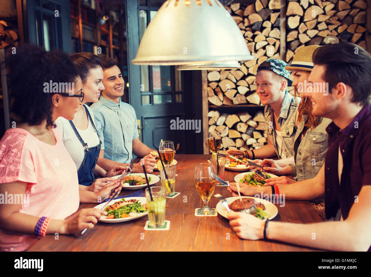 happy friends eating and drinking at bar or pub Stock Photo - Alamy
