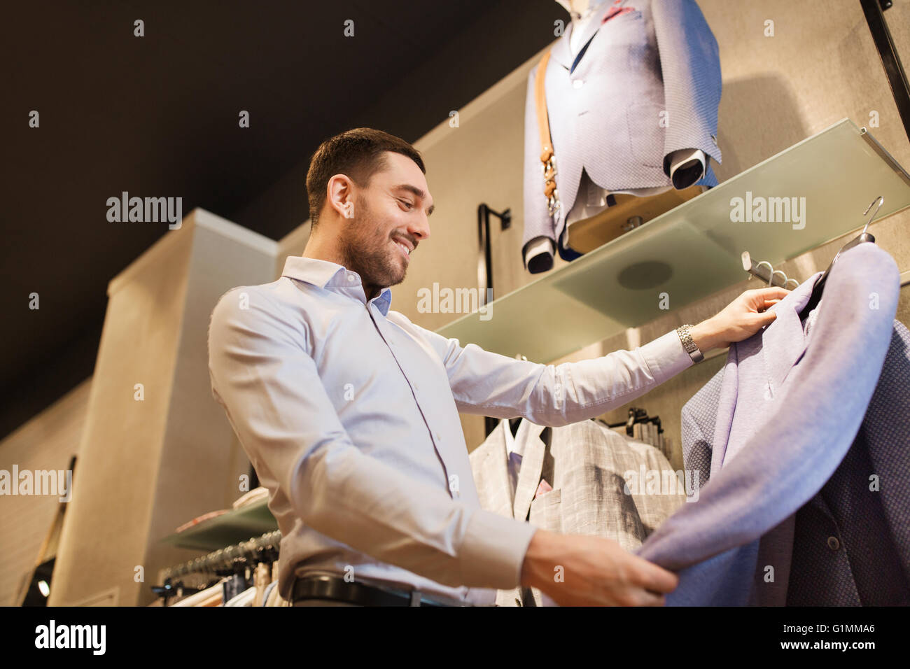 happy young man choosing clothes in clothing store Stock Photo - Alamy