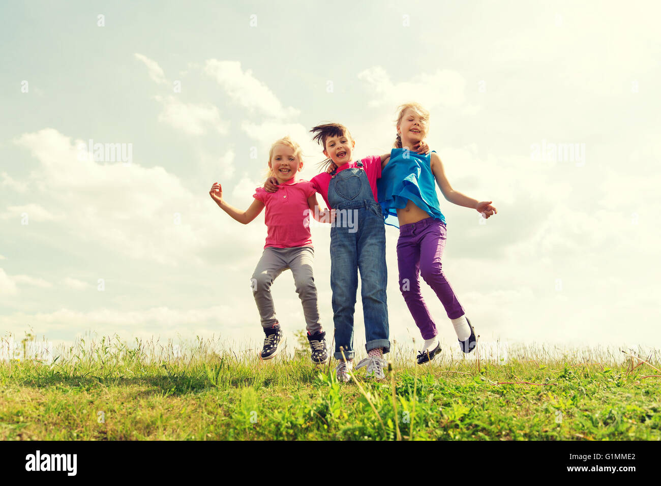 group of happy kids jumping high on green field Stock Photo - Alamy