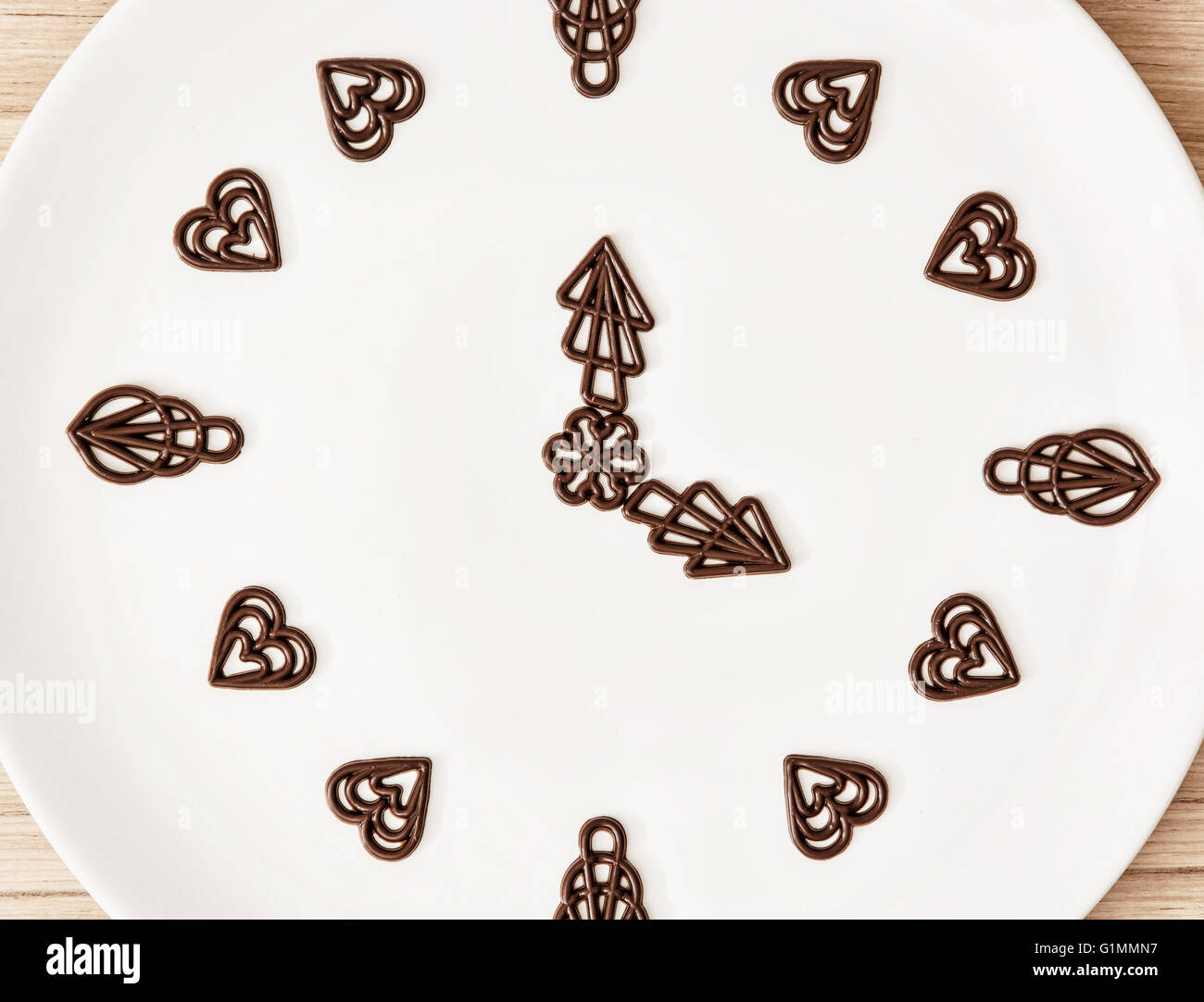 Dark chocolate garnishes in the shape of the clock. Symbolic food ...