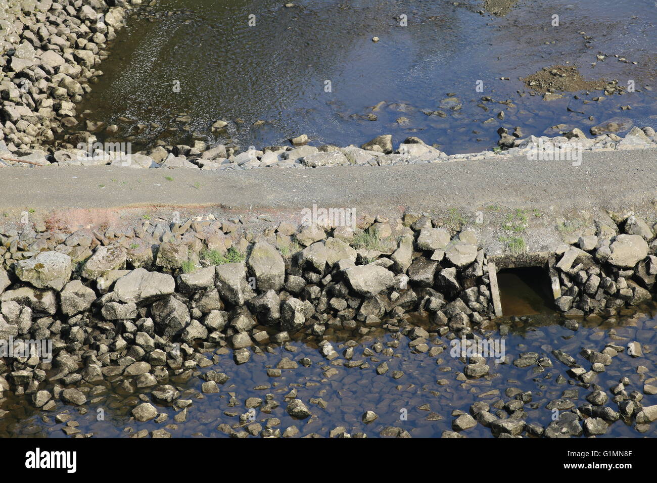 A rock dam with sewer for the water on both sides Stock Photo - Alamy
