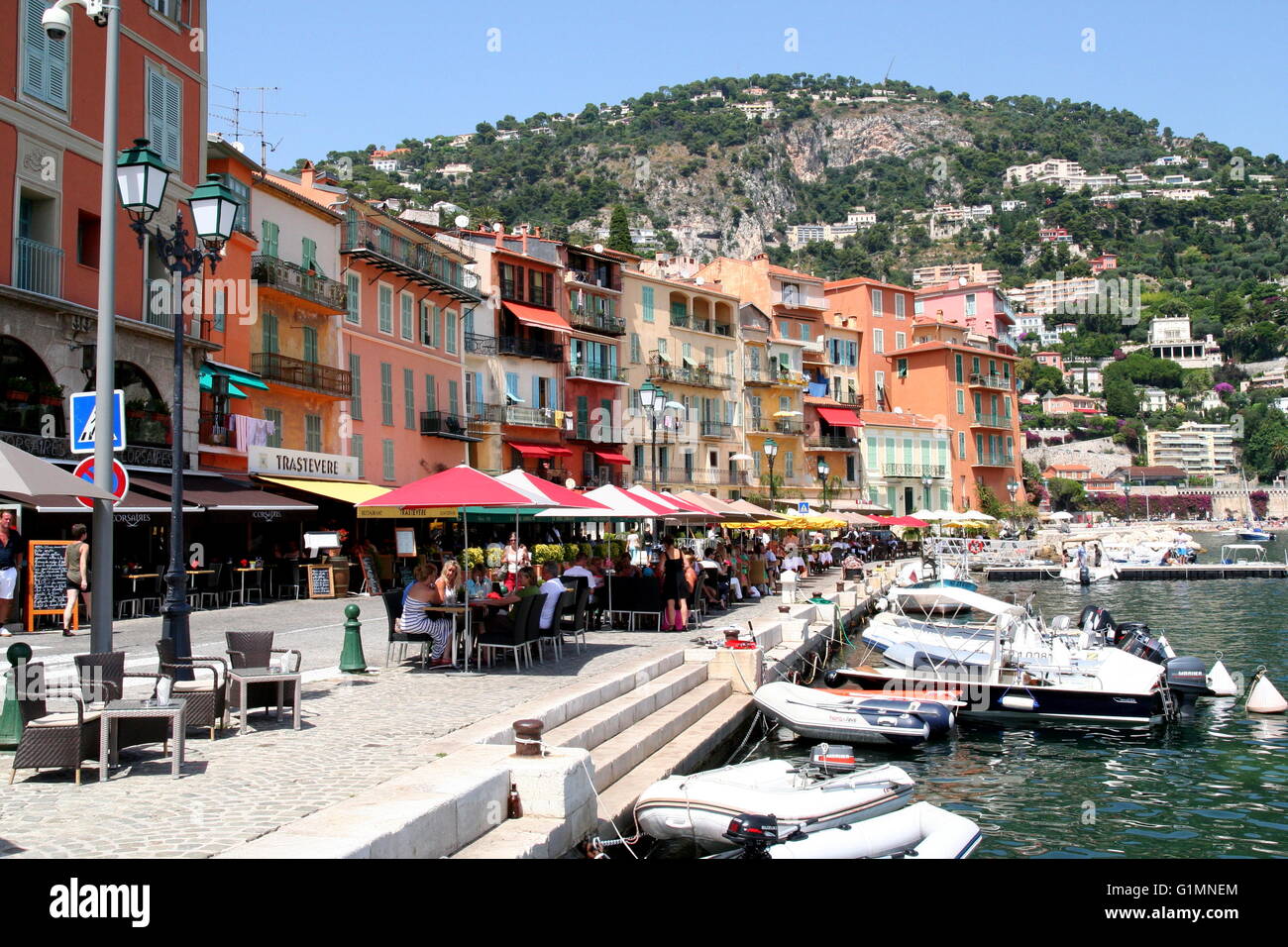 Crowded Cafés line the waterfront at Ville France sur Mer on the ...