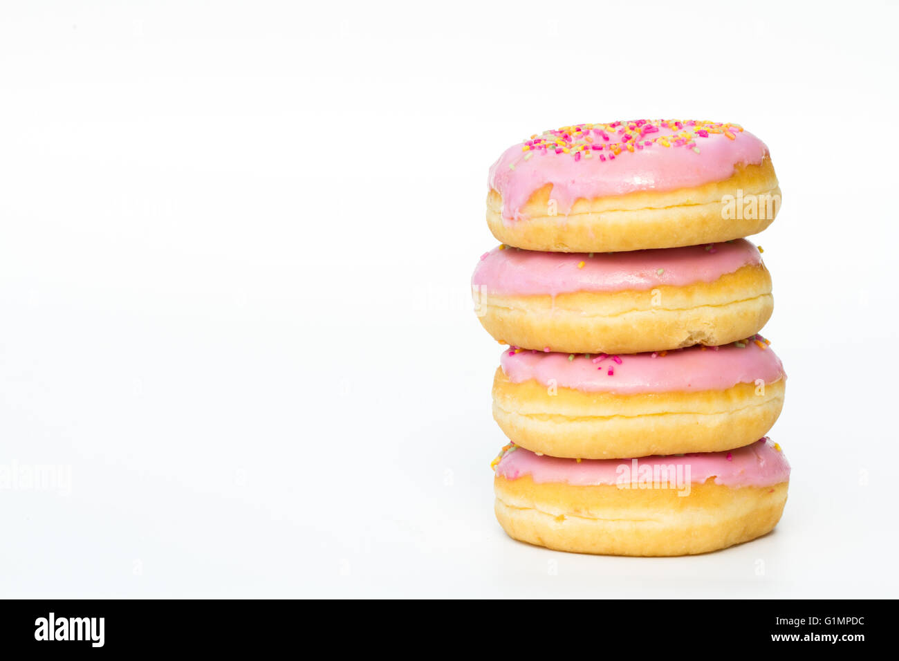 A stack of doughnuts with pink icing and sprinkles on an isolated white ...