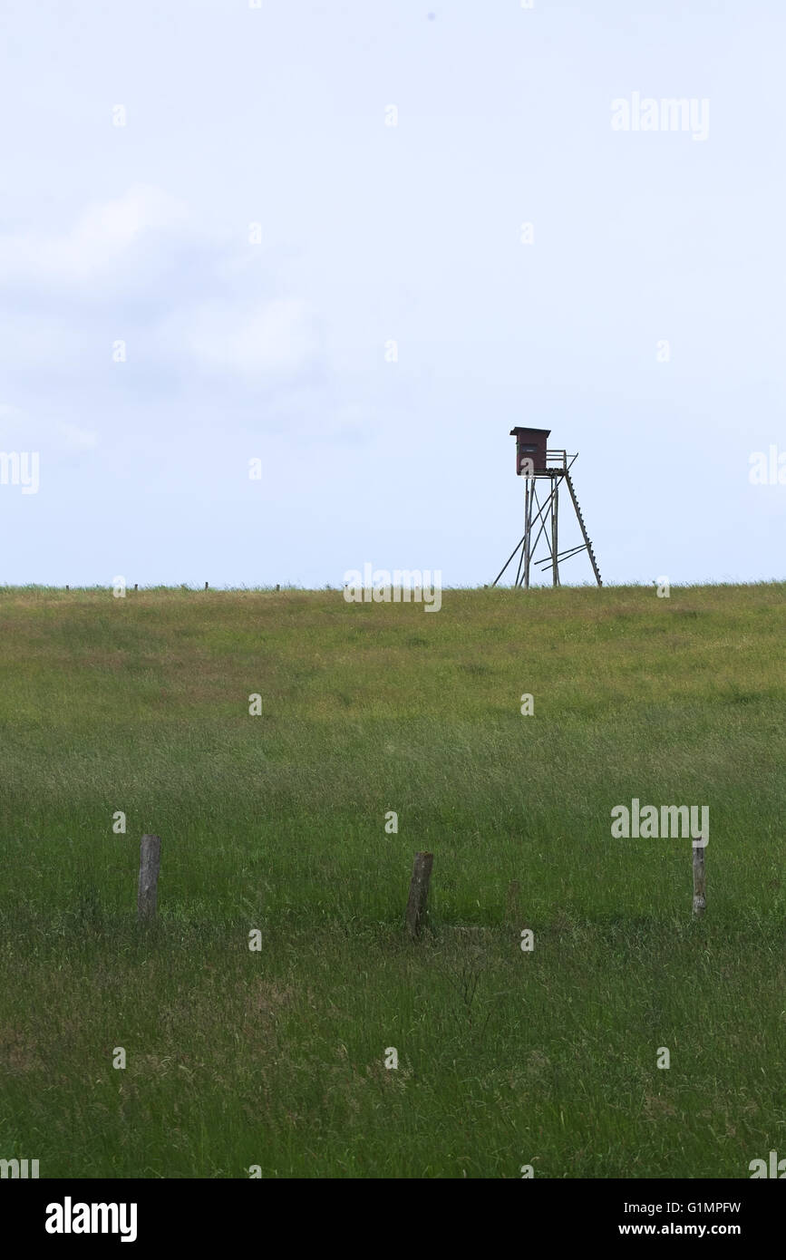 High seat on meadow with fence and overcast sky Stock Photo - Alamy