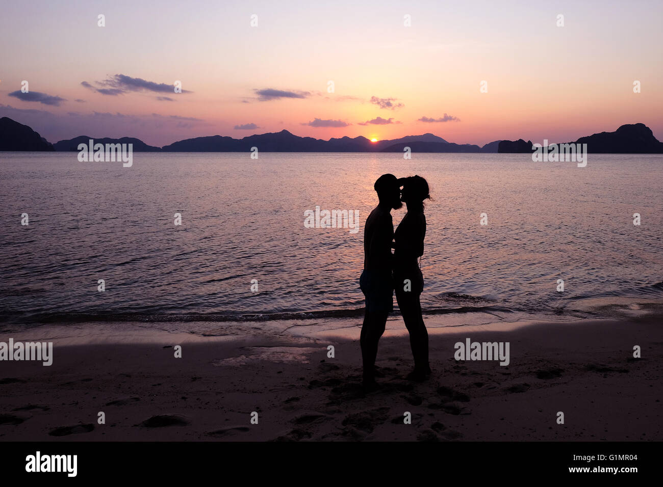 A couple kissing on the beach at sunset Stock Photo - Alamy