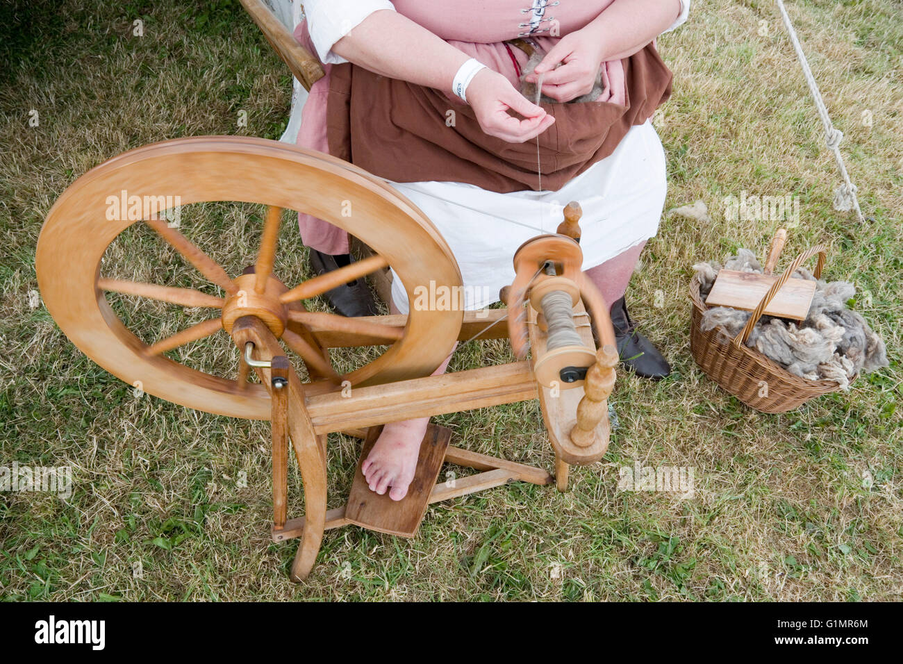 Tewkesbury, UK-July 17, 2015: Spinning wheel whirling and threading raw ...