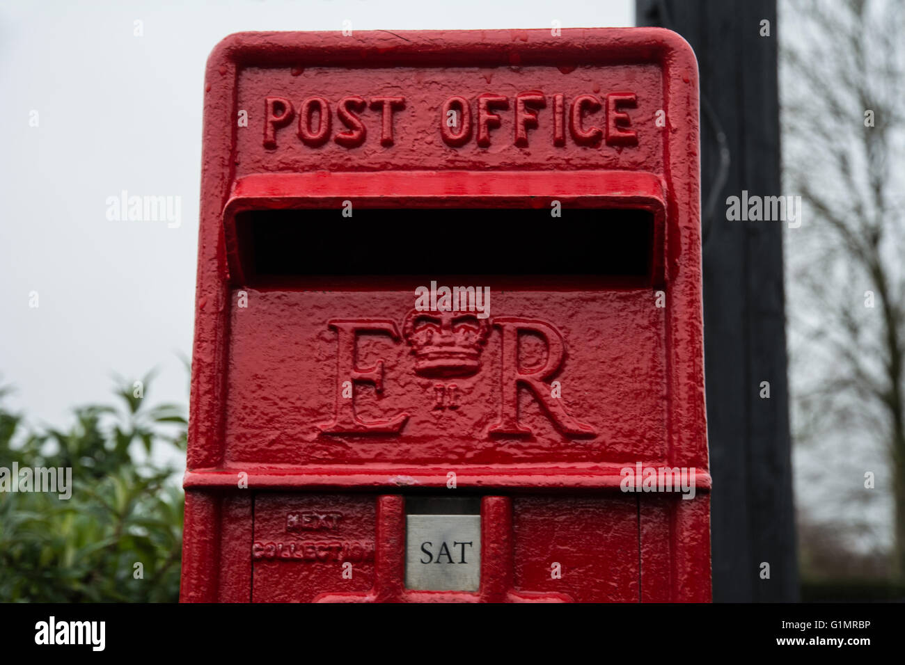 A close up of the mouth of a small post box with the collection times ...