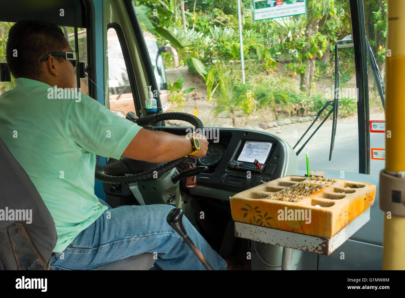 A bus driver driving an old bus with an old fashioned way of collecting ...