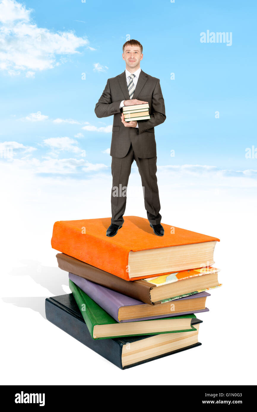 Man stand on pile of book and hold books Stock Photo - Alamy