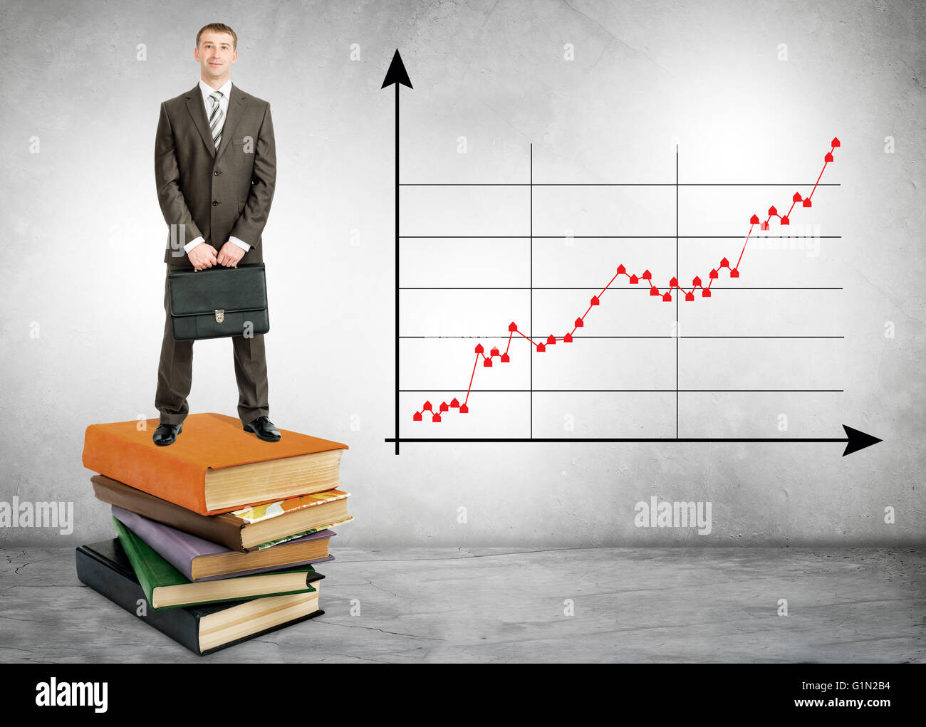 Businessman standing on books with chart Stock Photo - Alamy