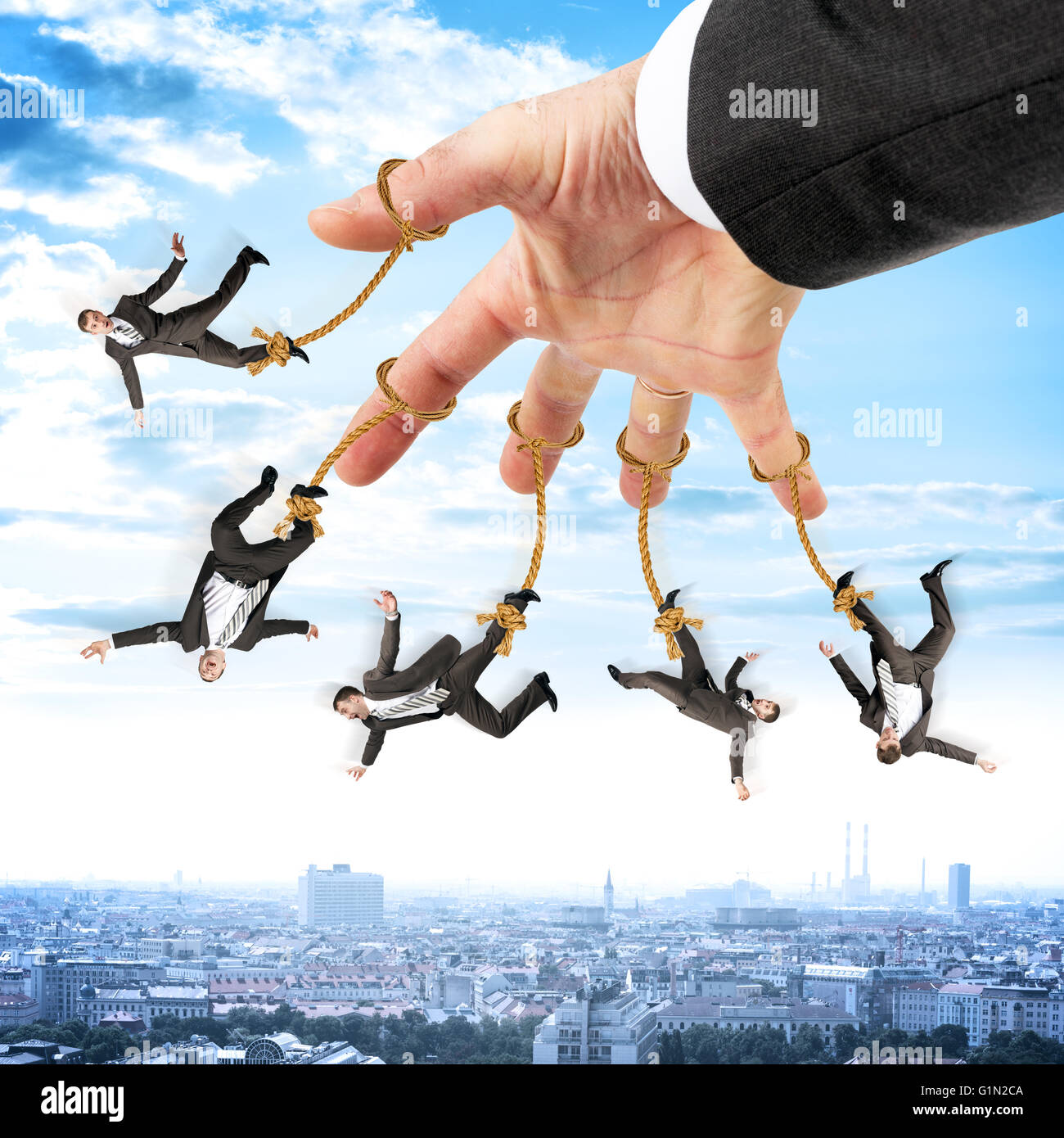 Businessmen hanging on strings like marionette Stock Photo - Alamy