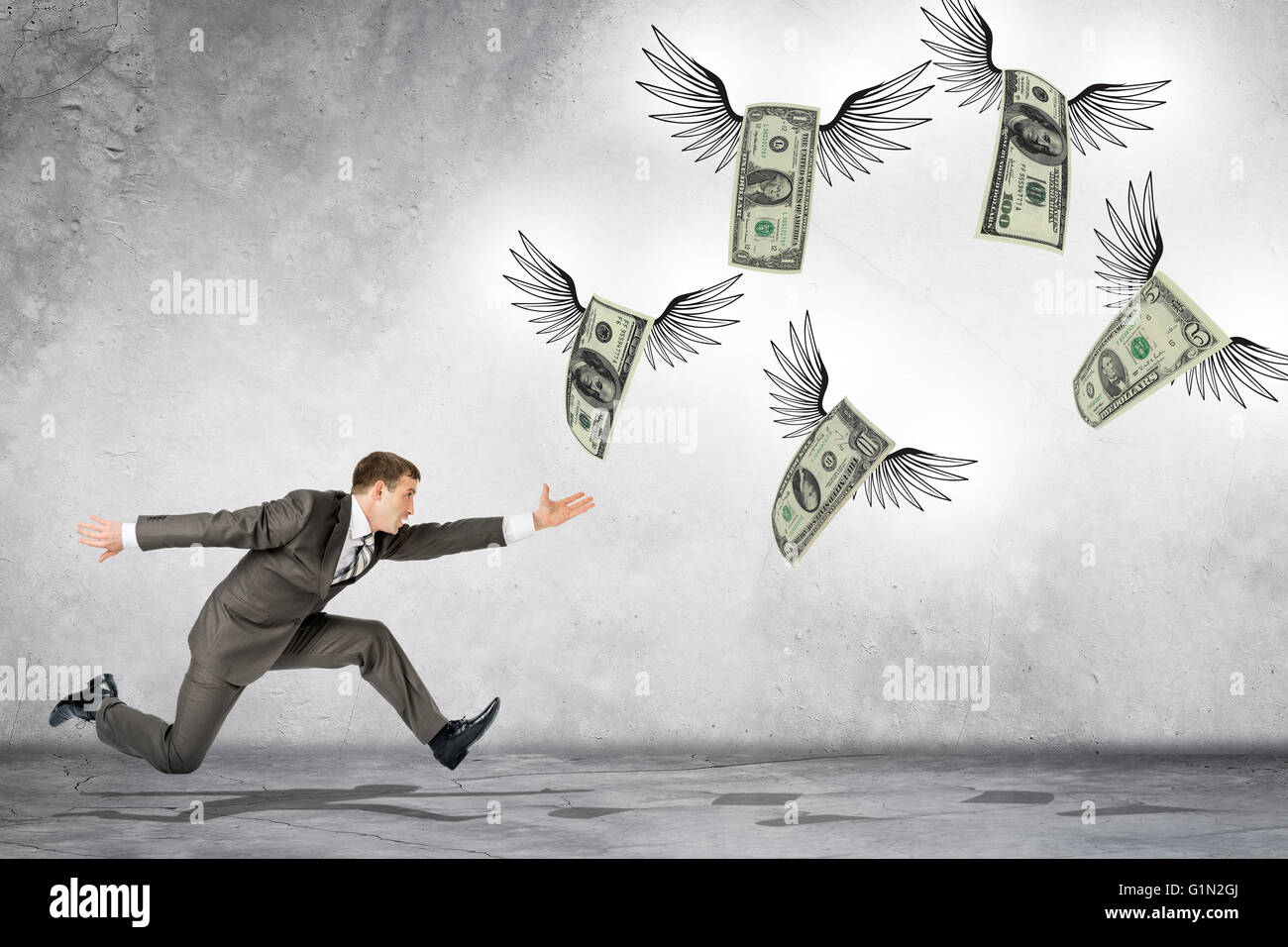 Business man running to catch flying dollars Stock Photo - Alamy