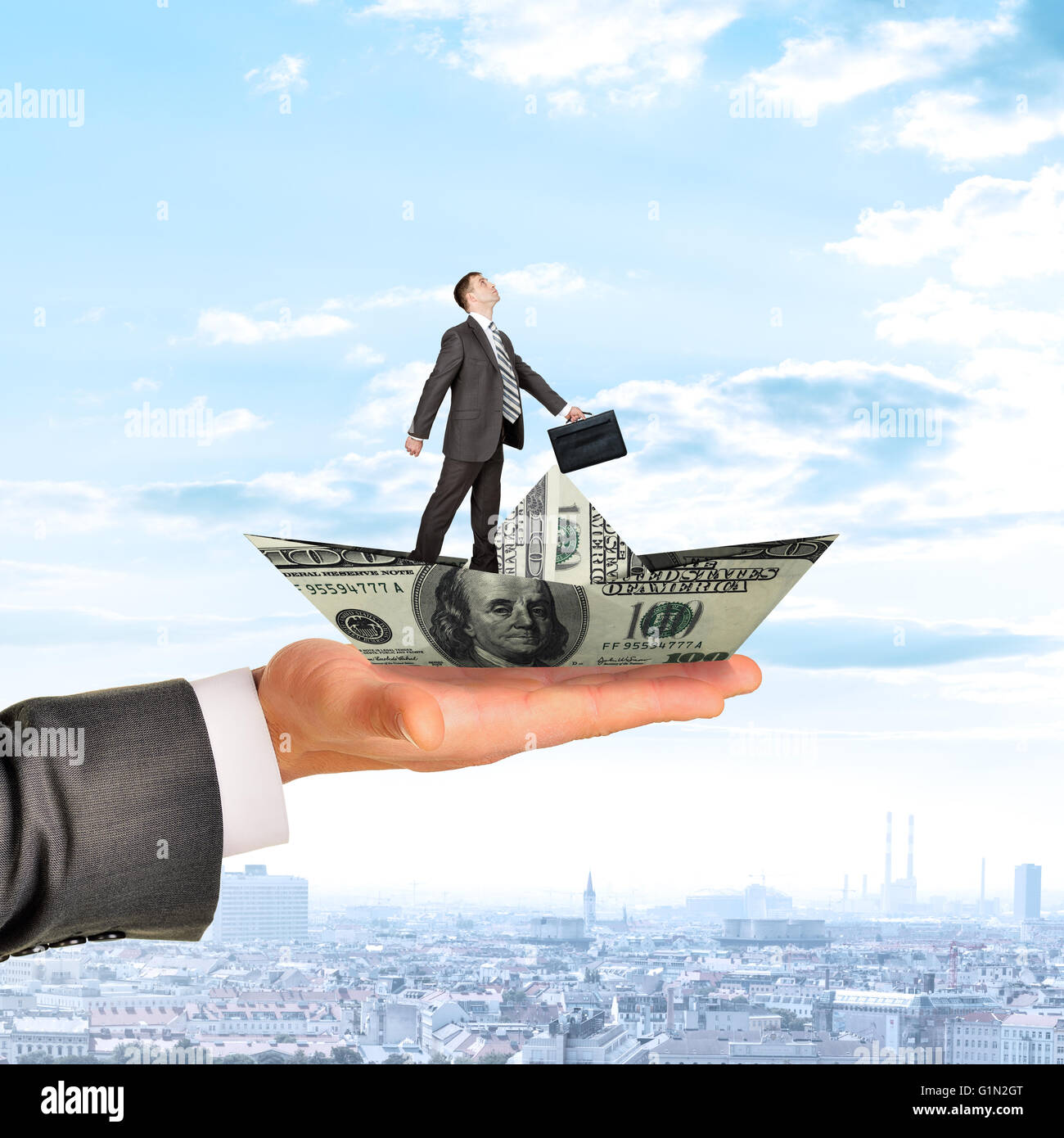 Businessman holding with care dollar banknote ship Stock Photo - Alamy