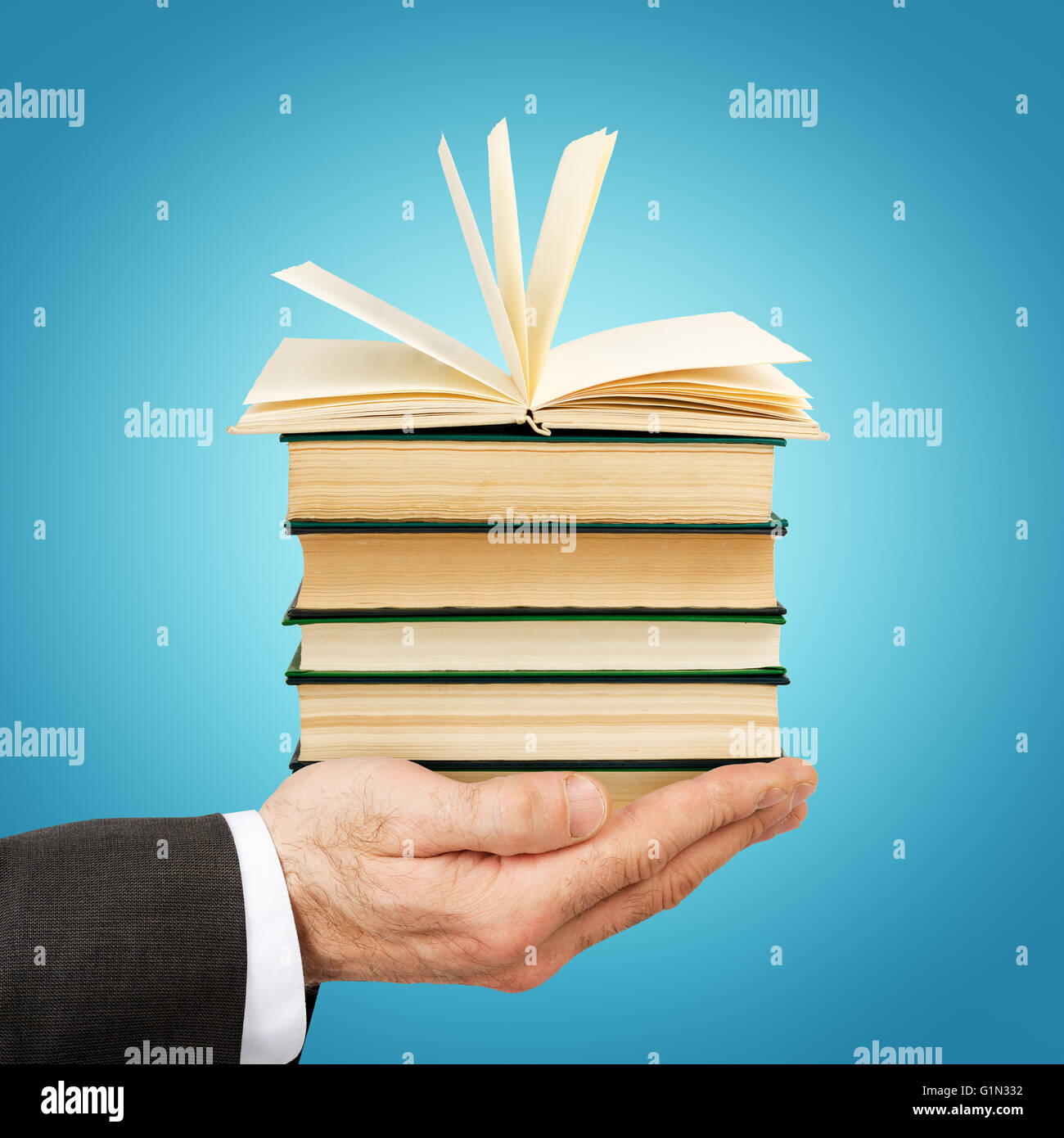 Business man holding stack of books Stock Photo - Alamy