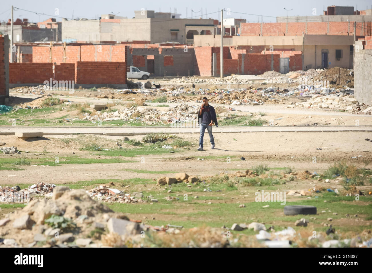 Man walking through the residential buildings and typical dusty and ...