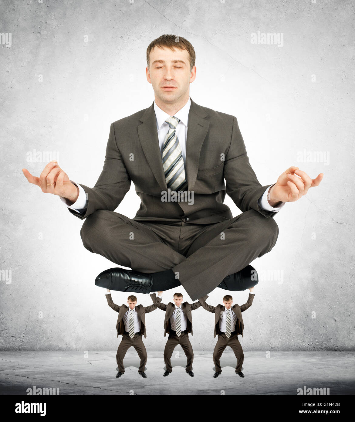Giant business man sitting on little men Stock Photo - Alamy