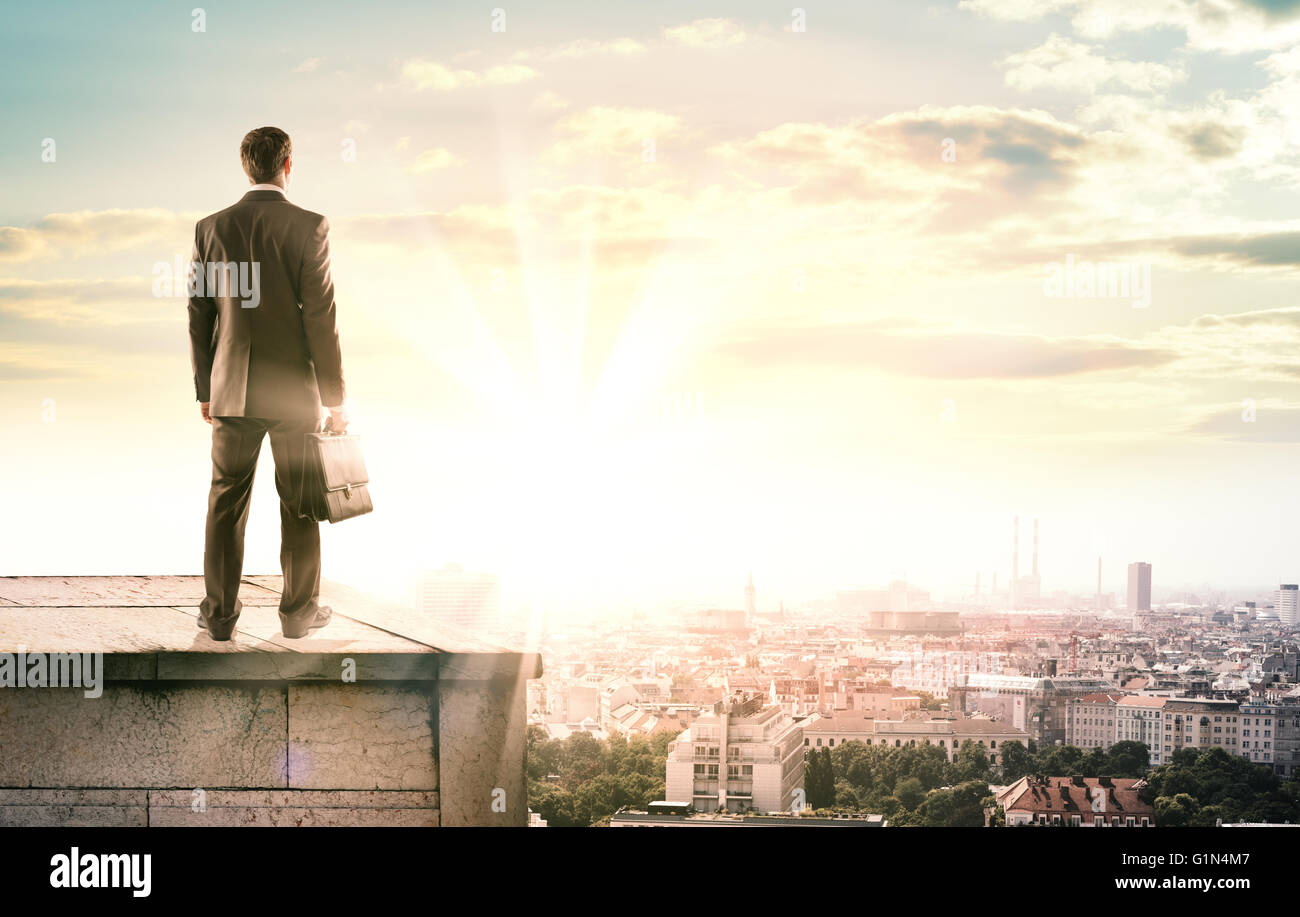 Businessman standing on roof Stock Photo - Alamy